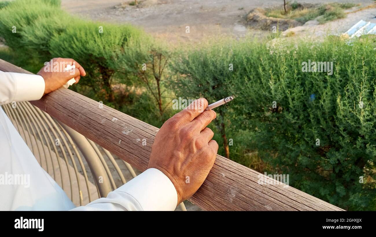 Person holding a cigarette in his hand and smoking on the balcony Stock ...