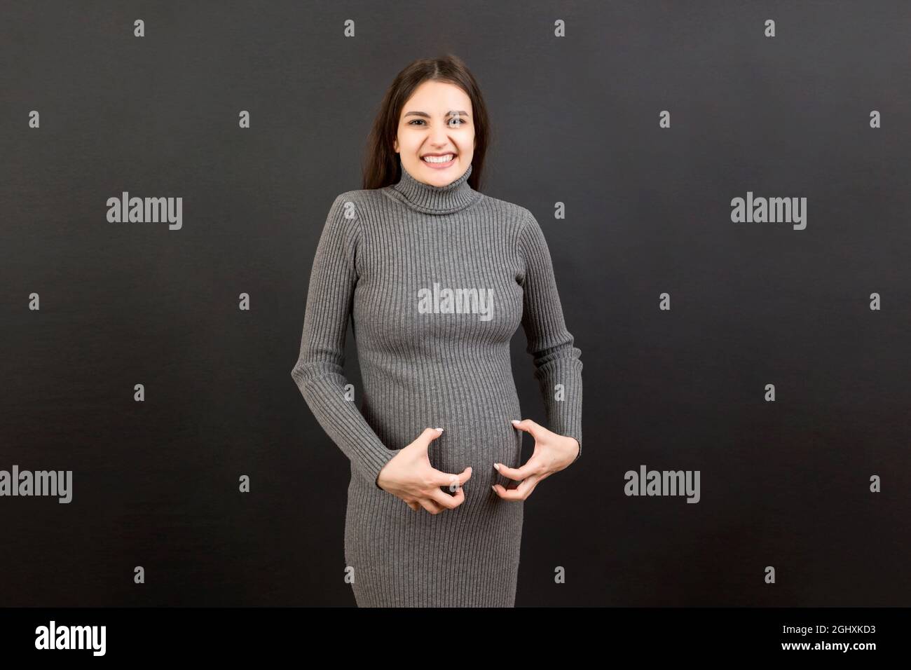Pregnant woman scratching her belly on colored background Stock Photo ...