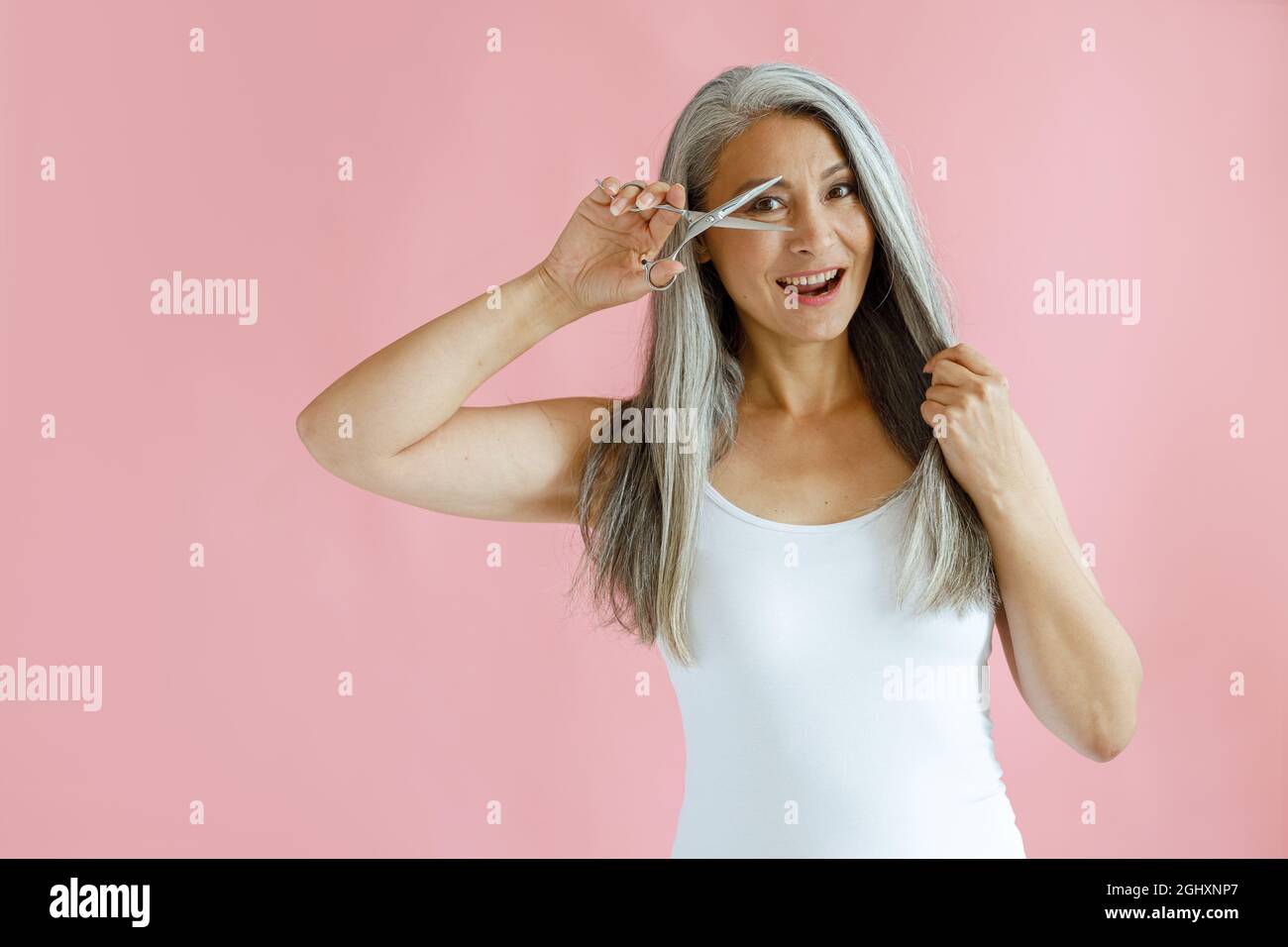 Happy middle aged woman with long hoary hair looks through open ...