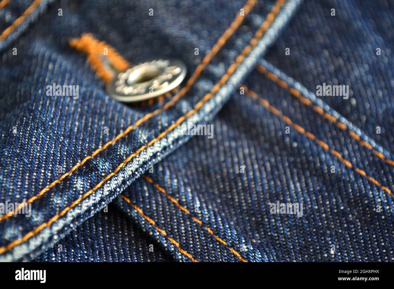 Yellow sewing on blue jeans from closeup. Studio shot at blue clothes ...