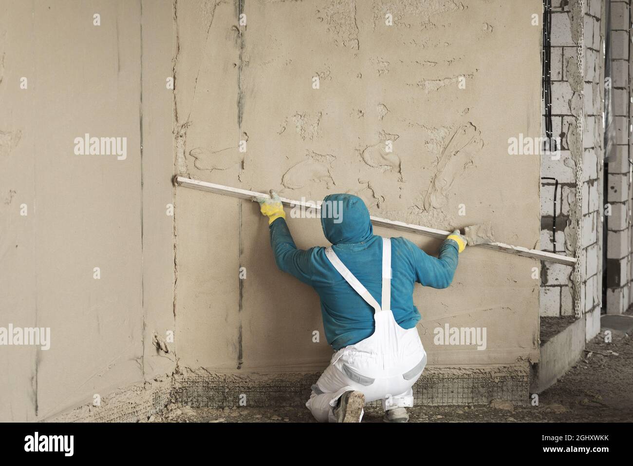 The process of leveling plaster by the rule after application by ...