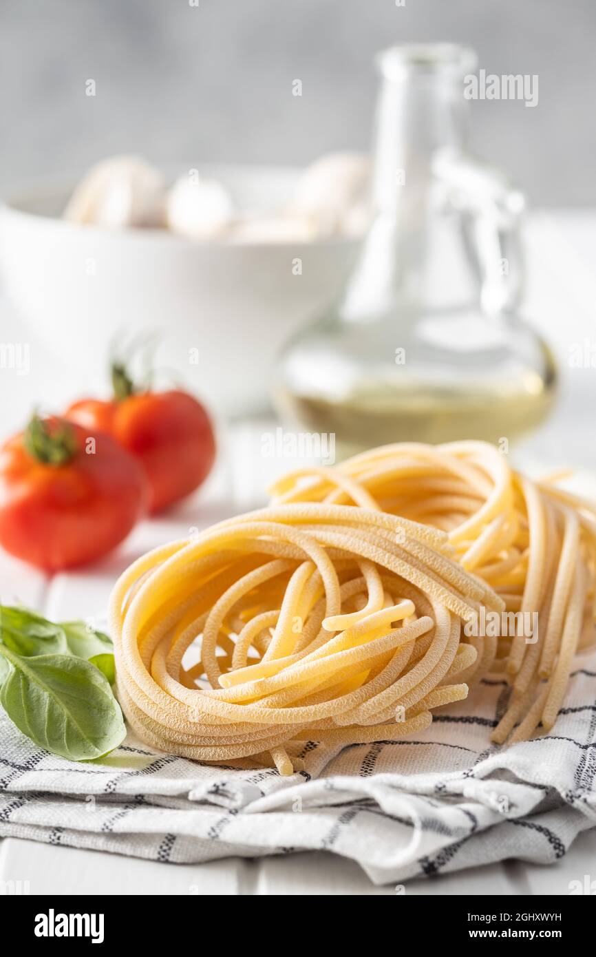 Italian pasta nest. Uncooked spaghetti nest on white table Stock Photo ...