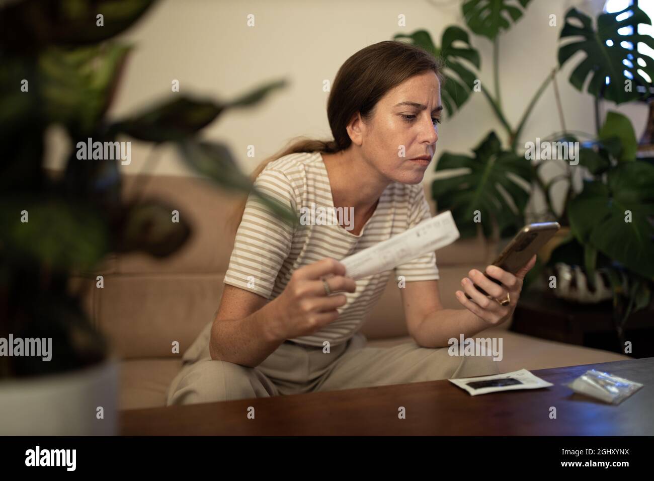 Woman reads instructions before performing a Covid-19 self-test at home ...