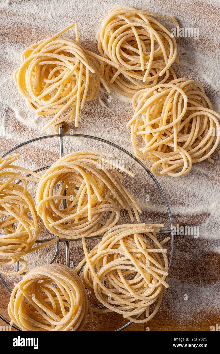 Italian pasta nest. Uncooked spaghetti nest and flour. Top view Stock ...