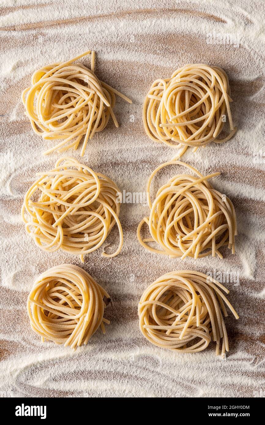 Italian pasta nest. Uncooked spaghetti nest and flour. Top view Stock ...