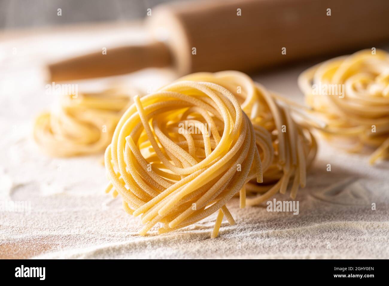 Italian pasta nest. Uncooked spaghetti nest and flour Stock Photo - Alamy