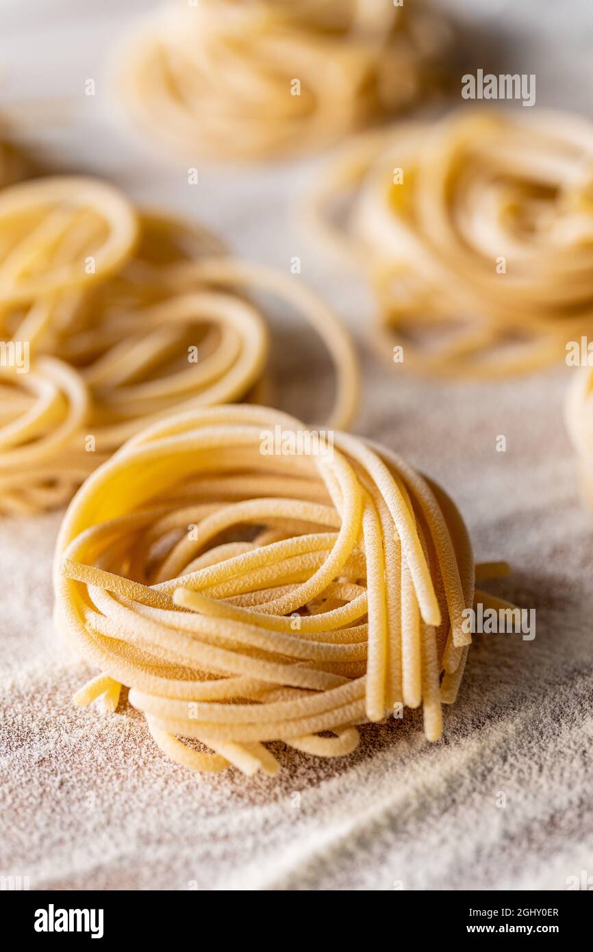 Italian pasta nest. Uncooked spaghetti nest and flour Stock Photo - Alamy