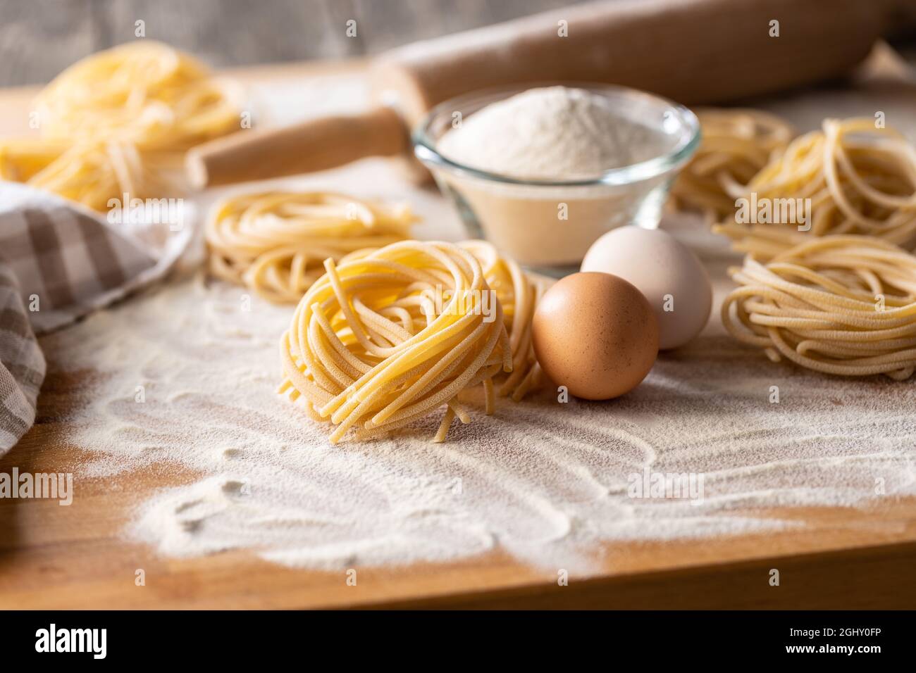 Italian pasta nest. Uncooked spaghetti nest and flour Stock Photo - Alamy