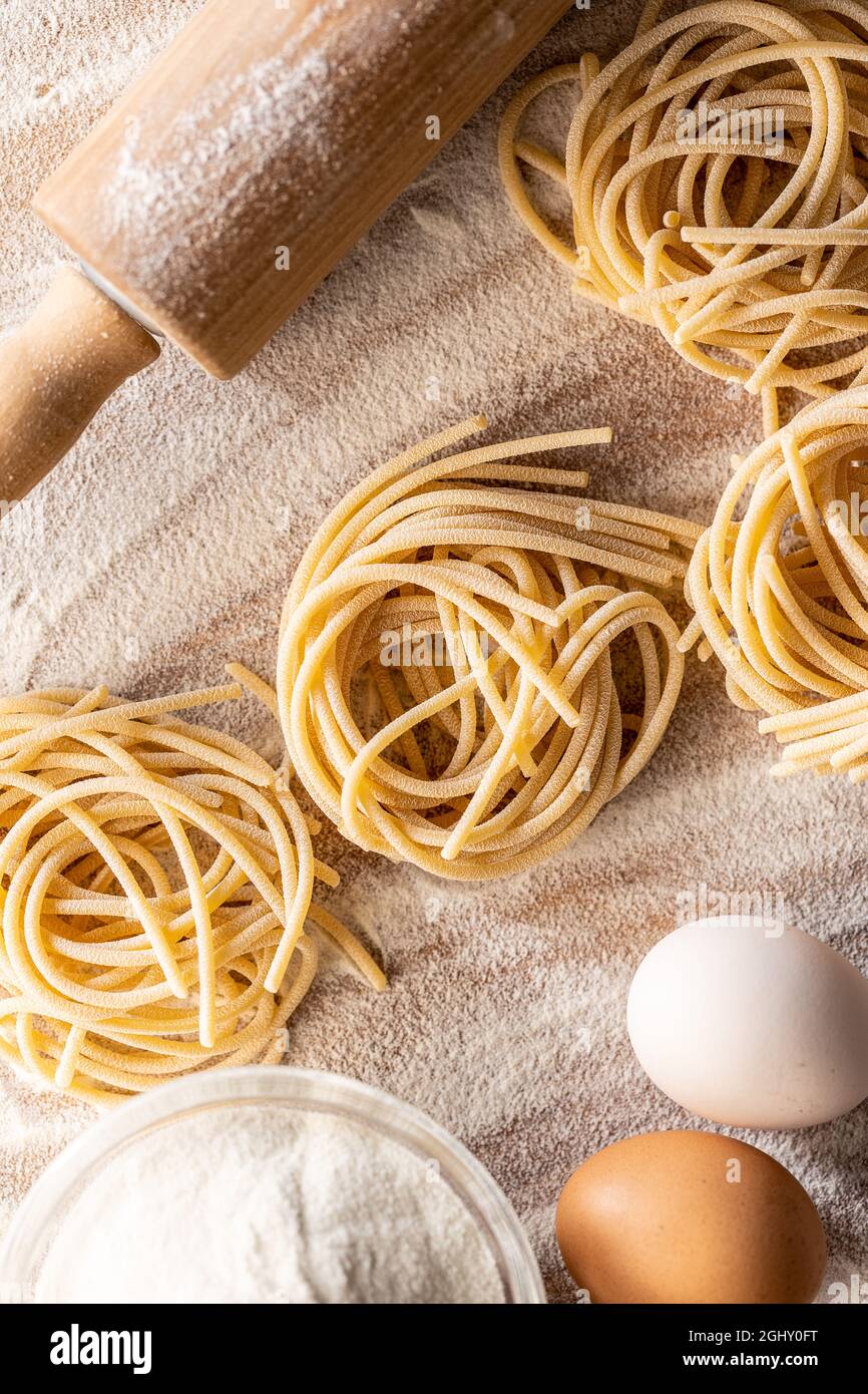 Italian pasta nest. Uncooked spaghetti nest and flour. Top view Stock ...