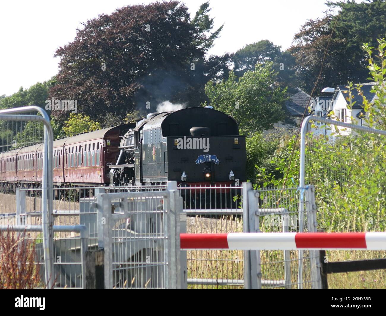 The Jacobite steam train passes through the level crossing at Corpach ...