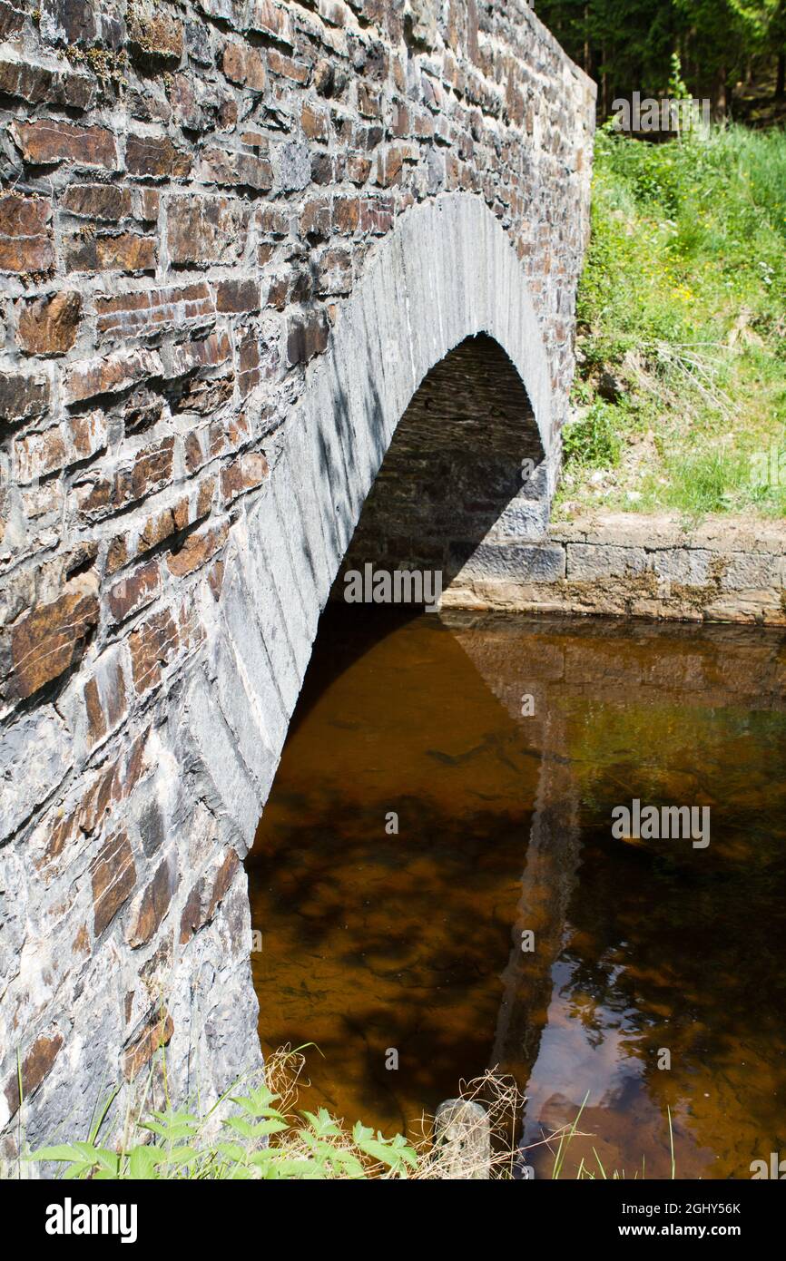 Vertical shot of a brick bridge over a small canal with little water ...
