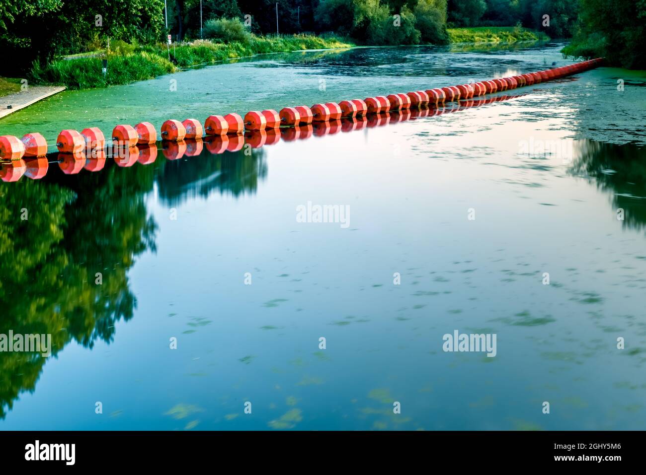 Still calm water in a section of river with a barrier Stock Photo - Alamy
