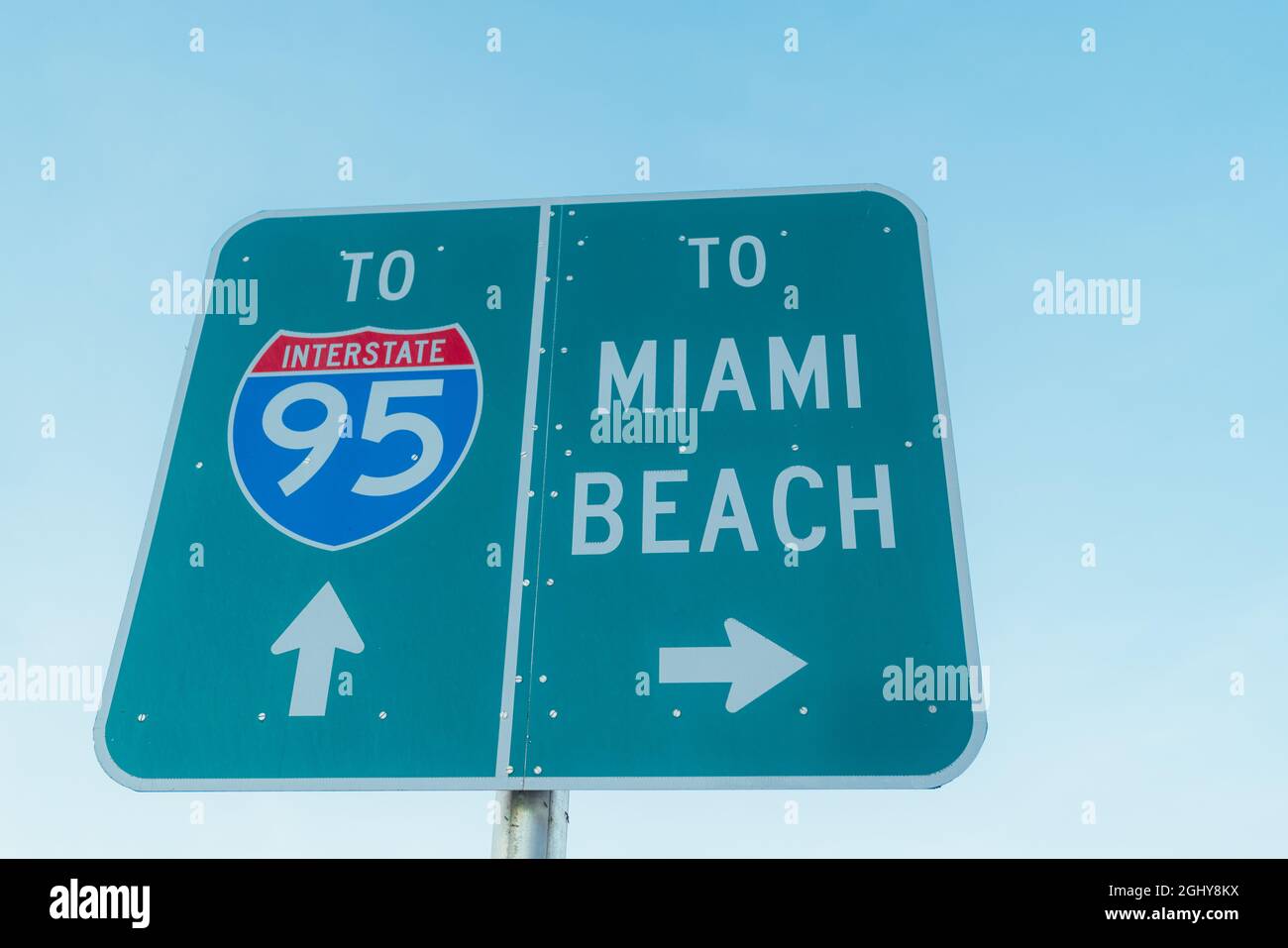 Low angle shot of a "to Miami Beach" road sign under the sunlight Stock ...