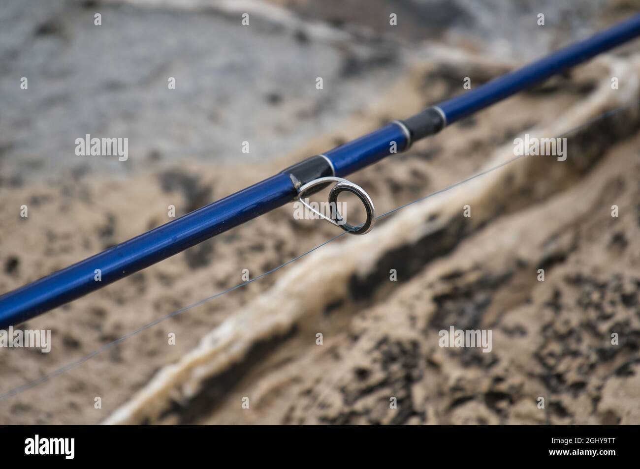 detail of fishing rod on the rocks. portrait Stock Photo - Alamy