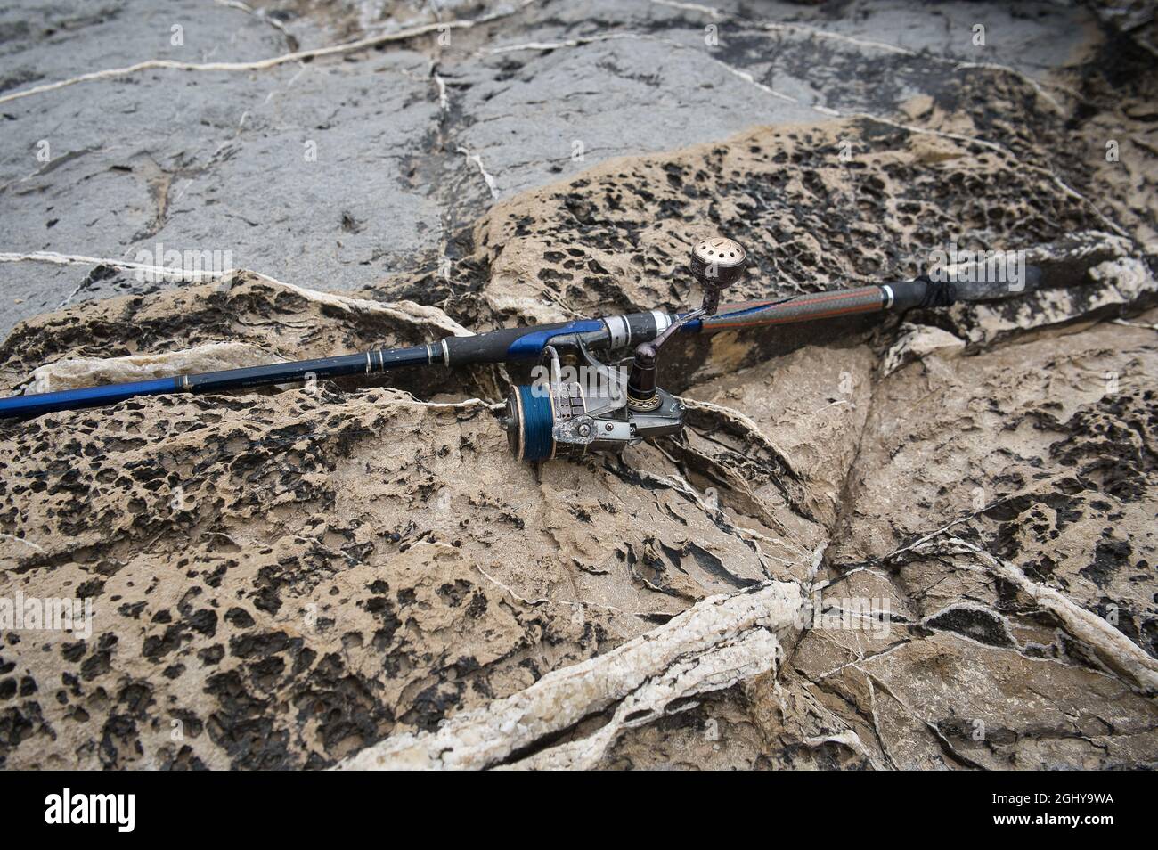 detail of fishing rod on the rocks. portrait Stock Photo - Alamy