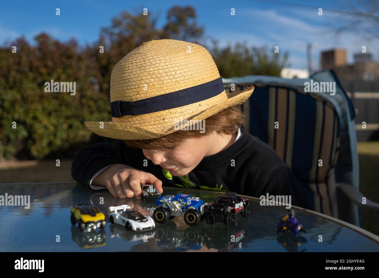 White Caucasian little kid playing outdoors with his toys Stock Photo ...
