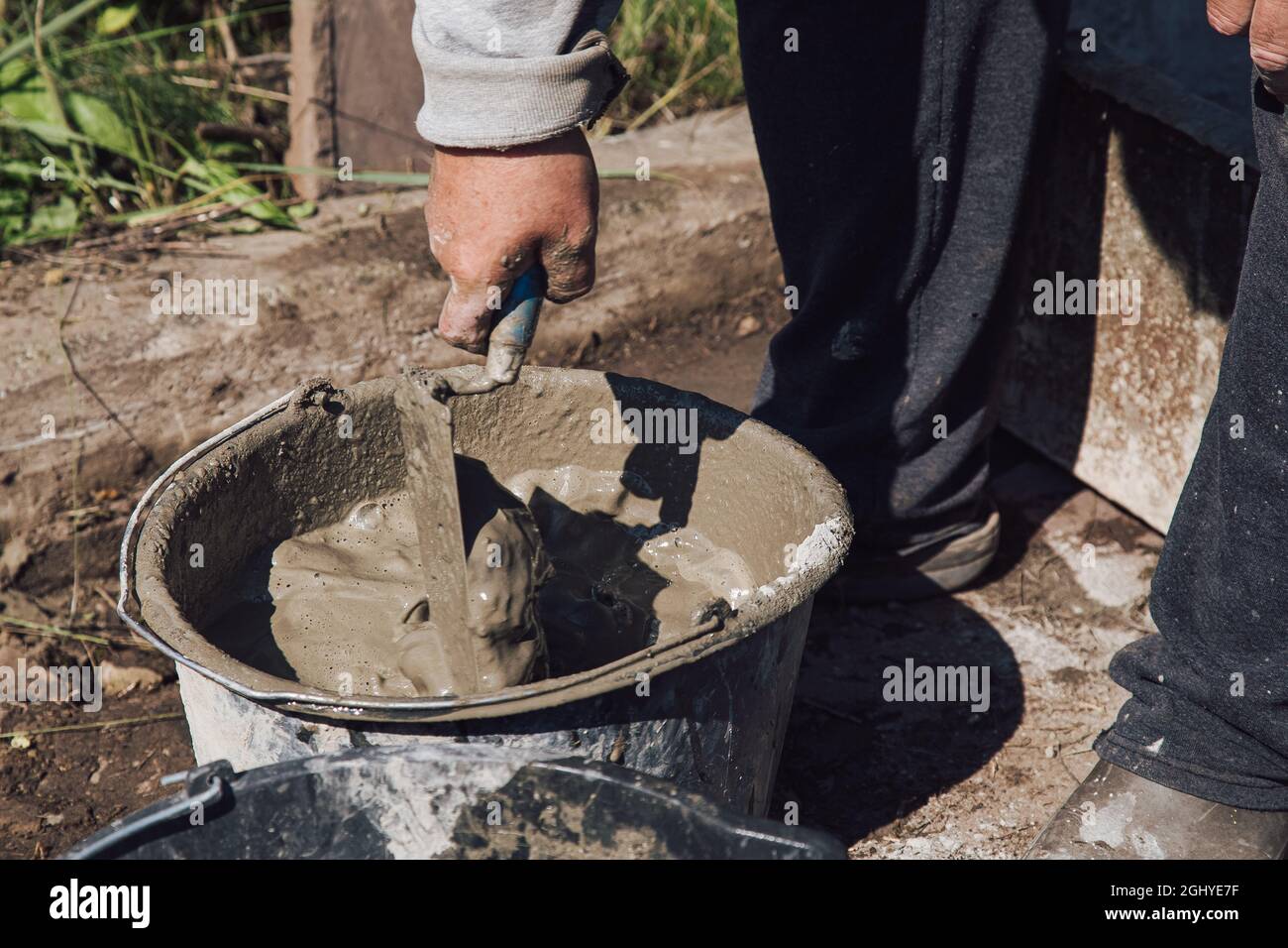 Mixing cement to fill the garden path, garden construction work Stock ...