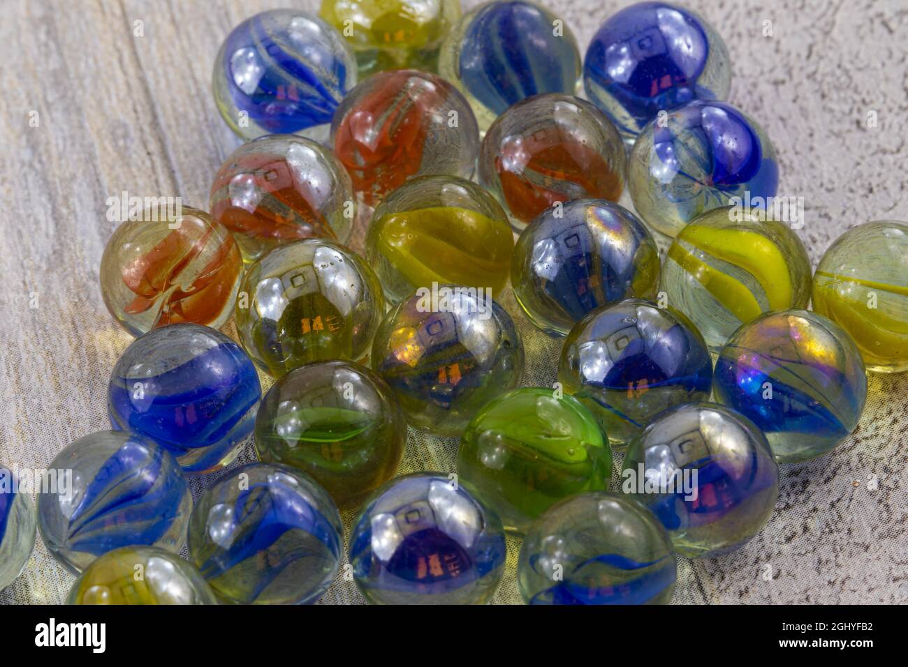 colored glass marbles on wooden background Stock Photo - Alamy