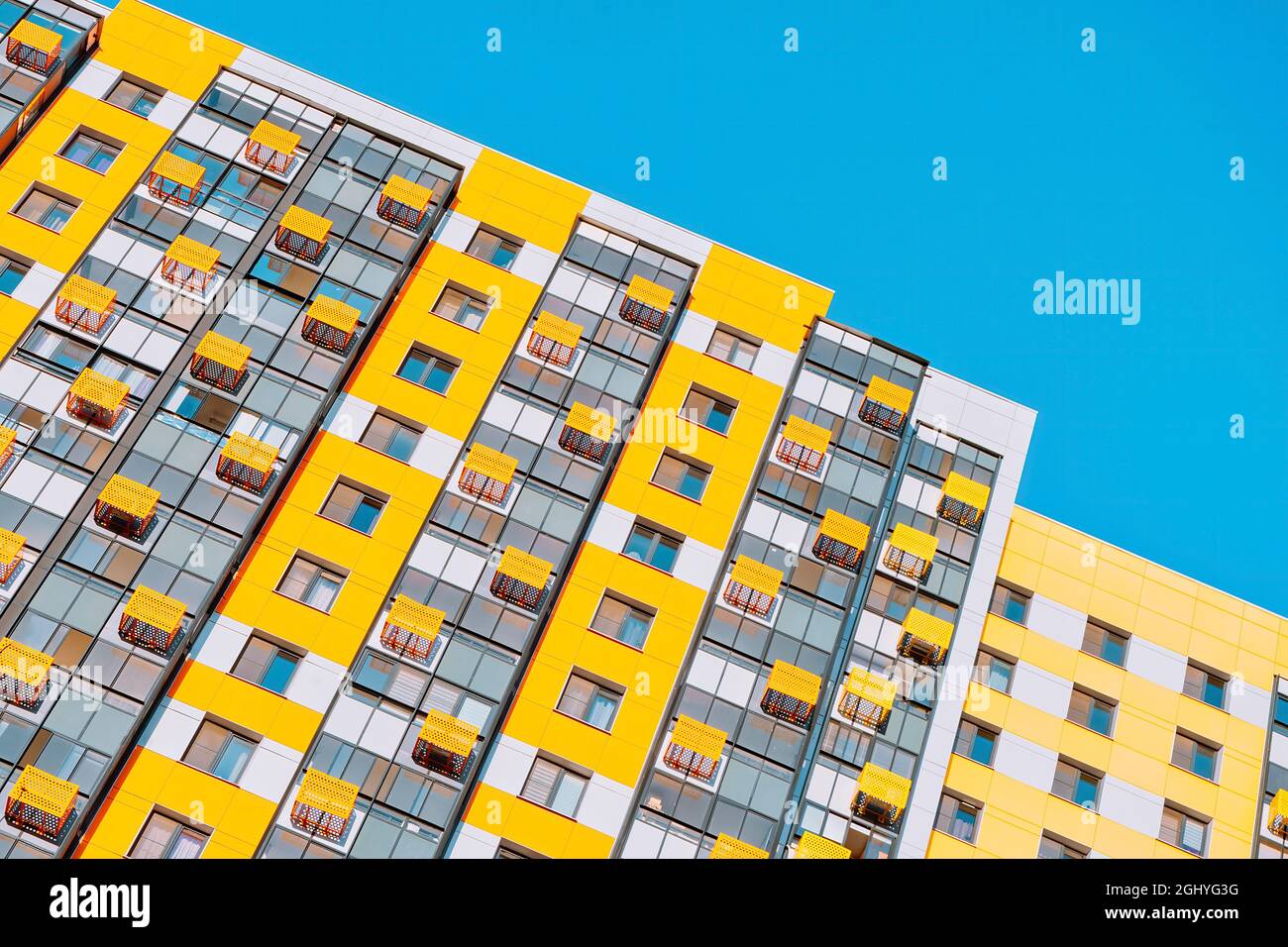 Residential building in yellow colors against blue sky Stock Photo - Alamy