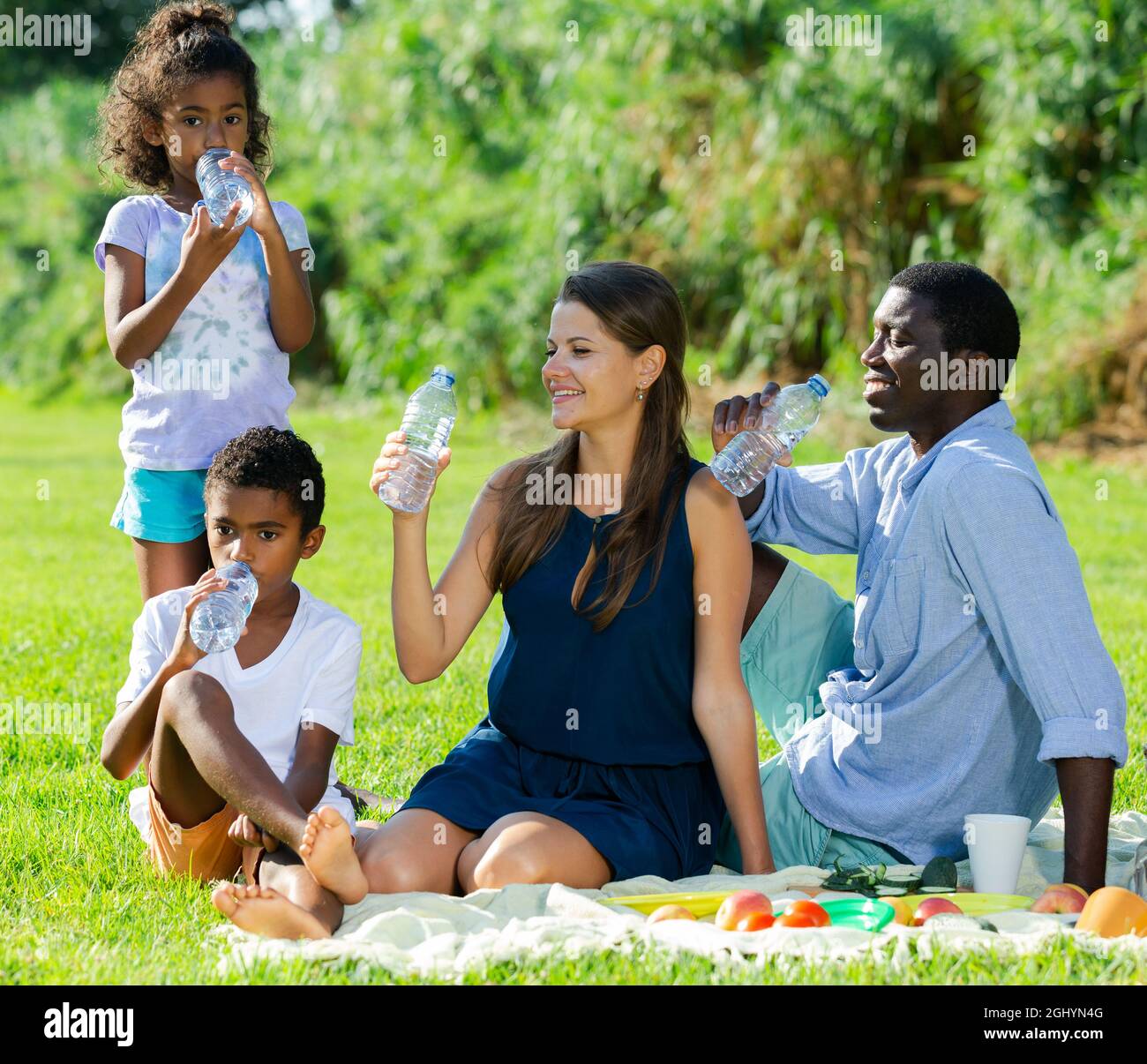 Family drinking water on picnic Stock Photo - Alamy
