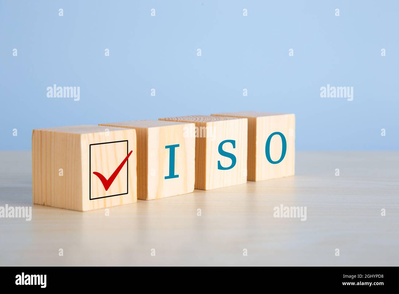The abbreviation ISO on wooden cubes with check mark on blue background ...