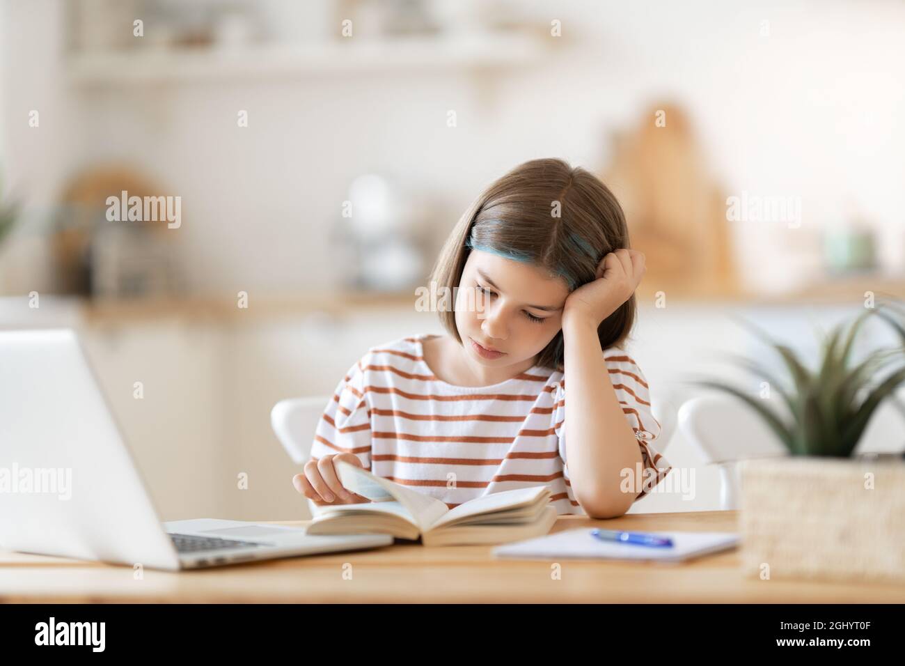 Back to school. Unhappy child is sitting at desk. Girl doing homework ...