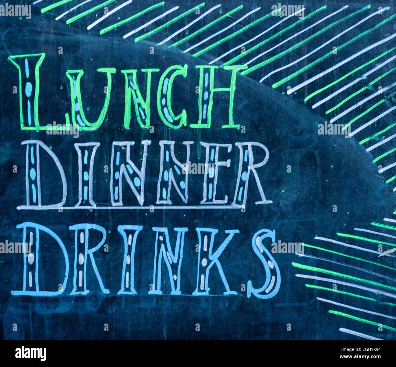 Chalkboard sign advertizing lunch, dinner and drinks in green and blue ...