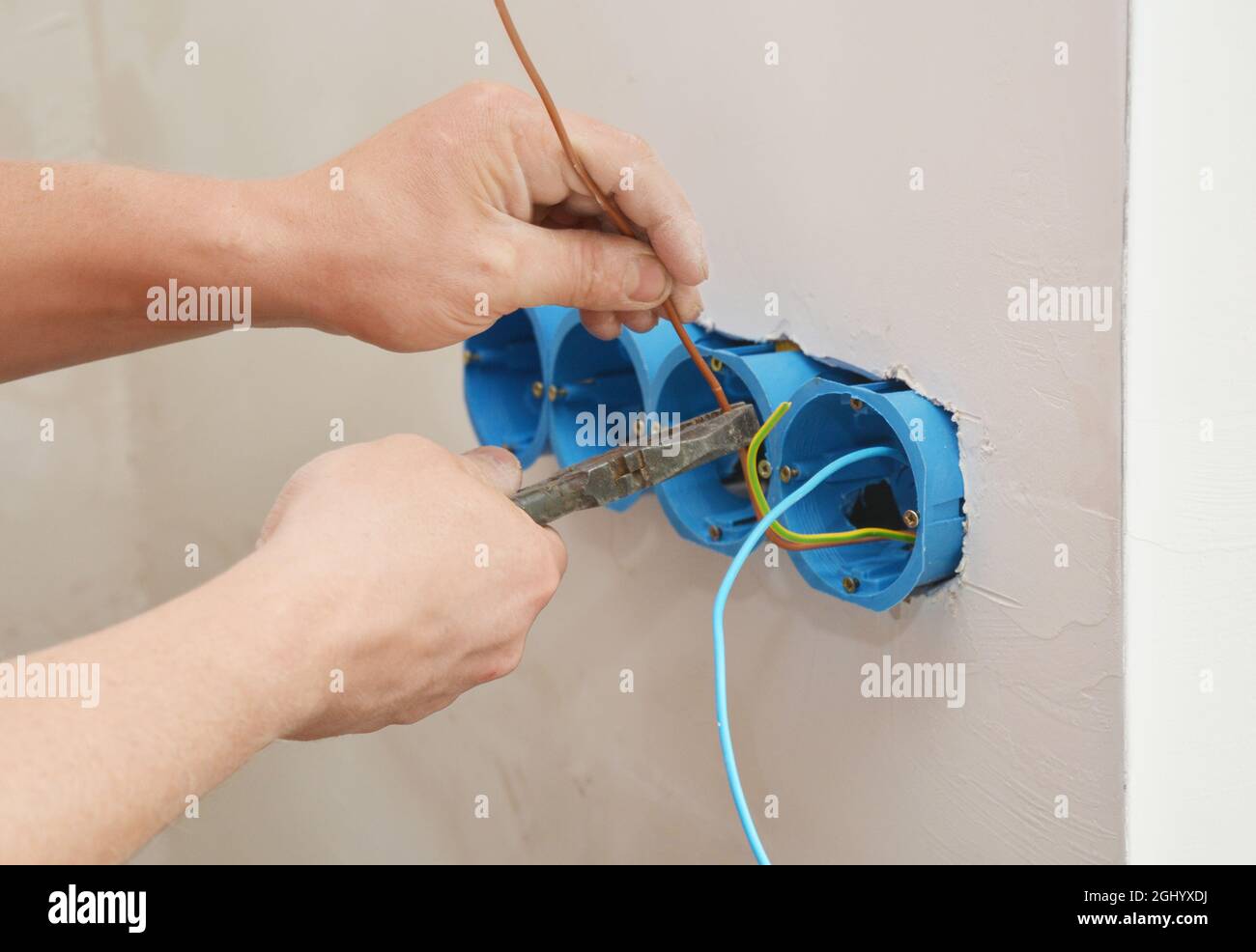 A building contractor is installing a new multi electrical outlet ...