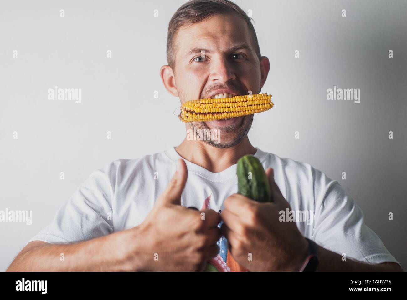 funny man eating corn on a white background Stock Photo - Alamy