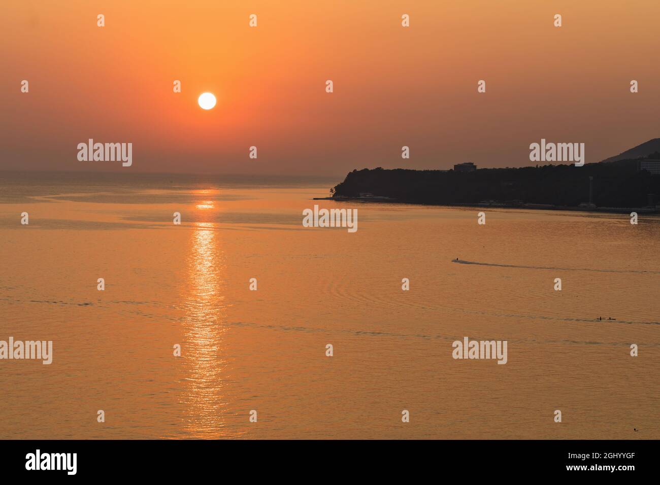 Beautiful cloudless sunset on the sea with sunlight reflected in the ...