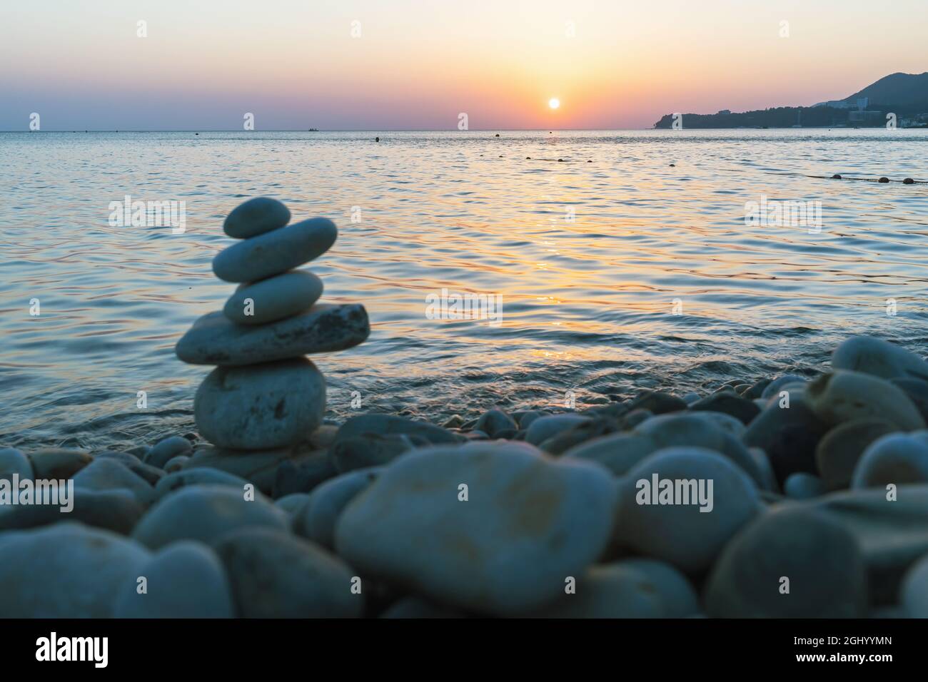 Beautiful sunset at sea and balancing pyramid of stones Stock Photo - Alamy