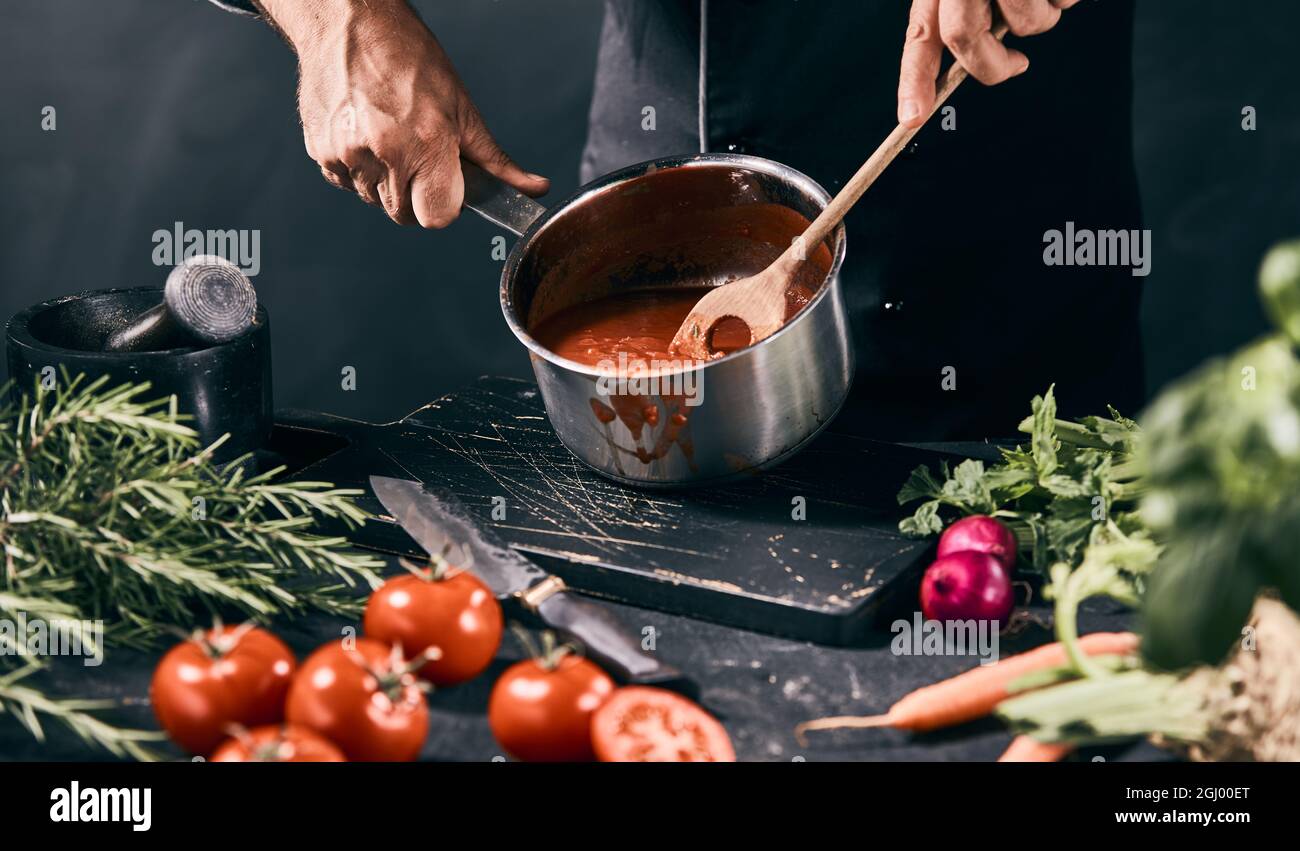 Crop faceless male chef cooking delicious vegetarian lunch while ...