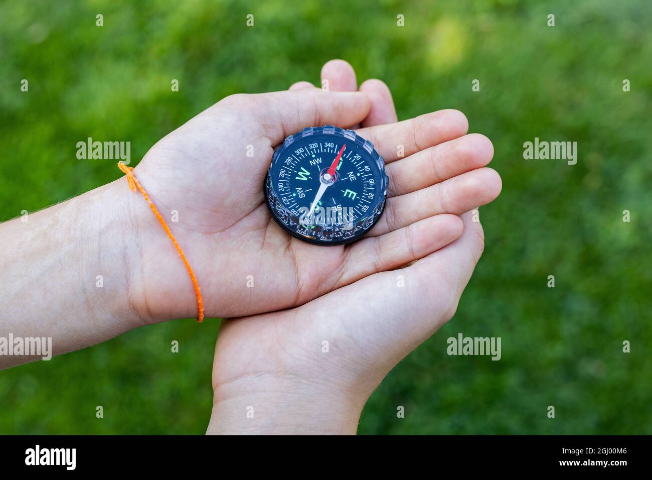Girl holding the compass. Hands of a teenager girl holding a liquid ...