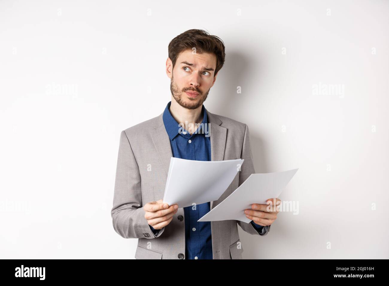 Businessman in suit looking through papers, reading documents at work ...