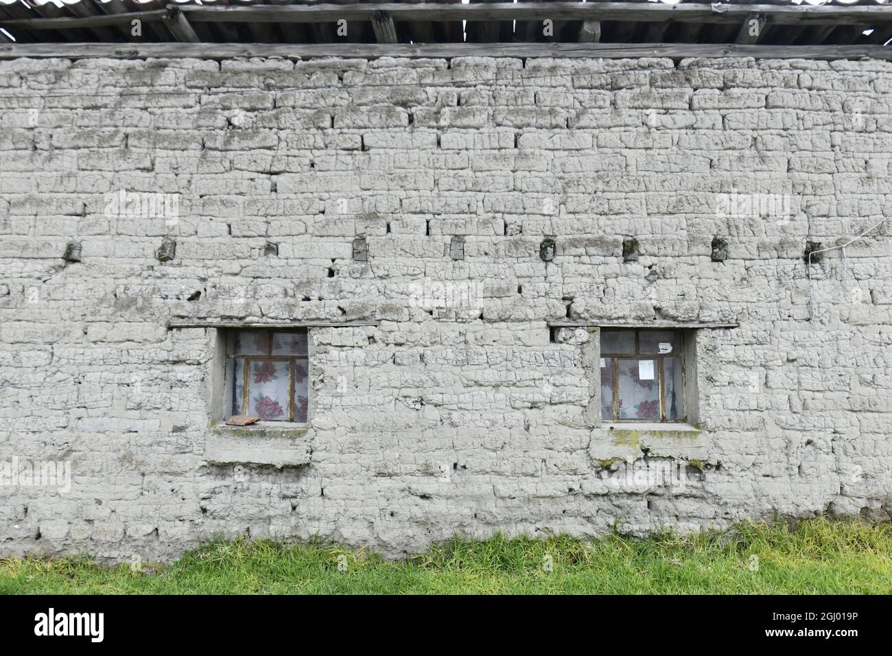 Old stone brick building with two vintage windows Stock Photo - Alamy