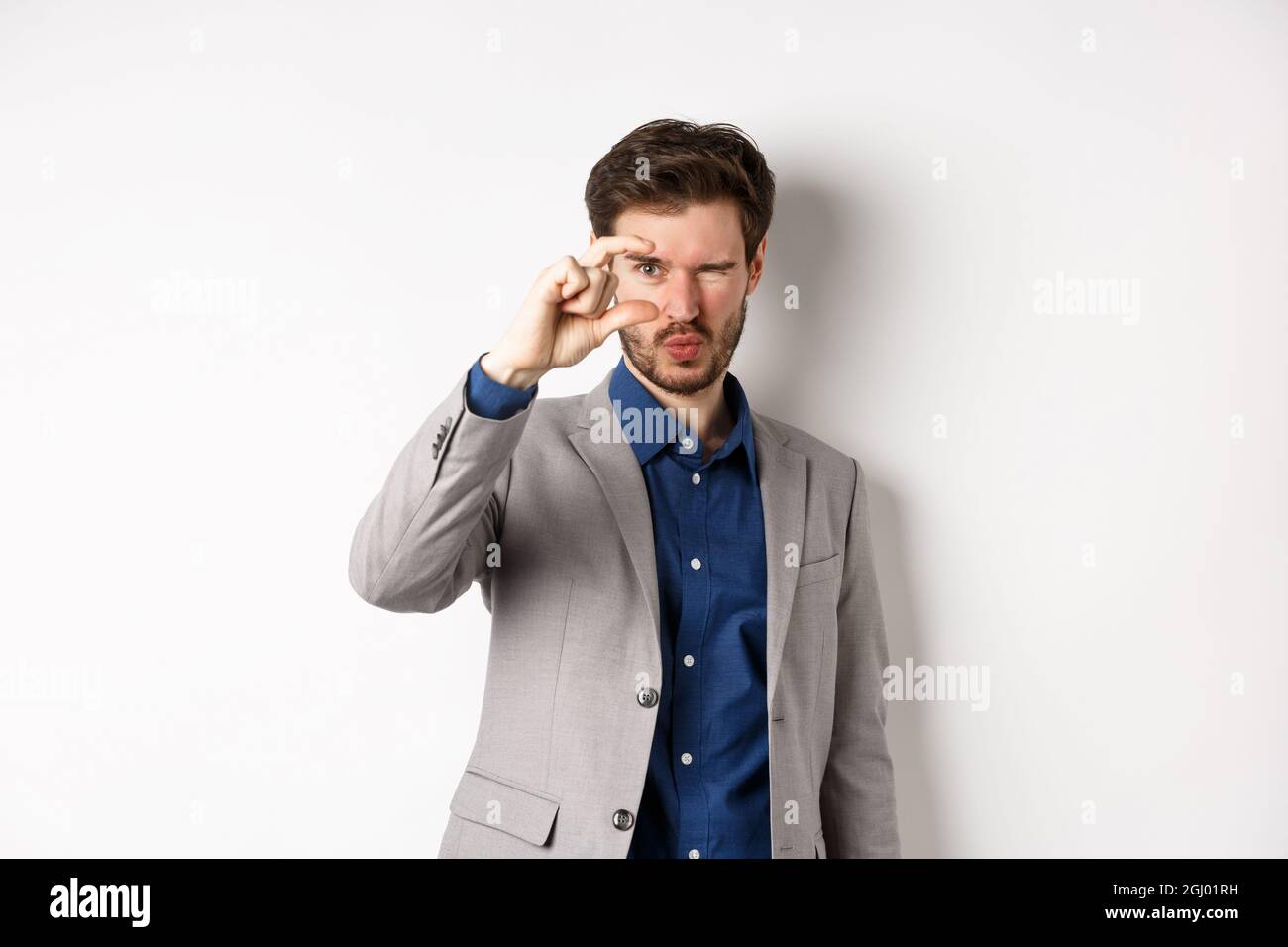 Businessman trying to see something tiny, showing small thing size with ...