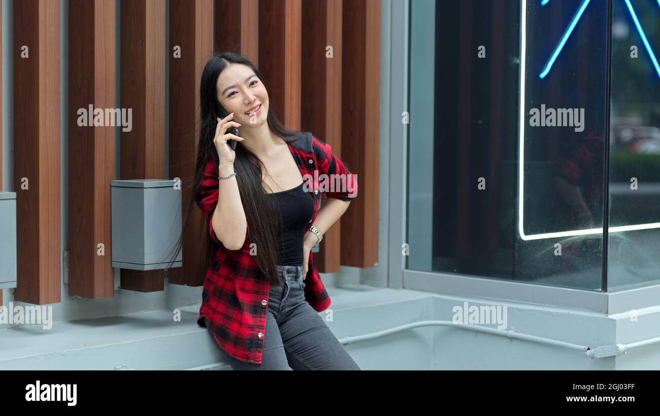 Elegant millennial woman talking on phone with friends at city mall ...