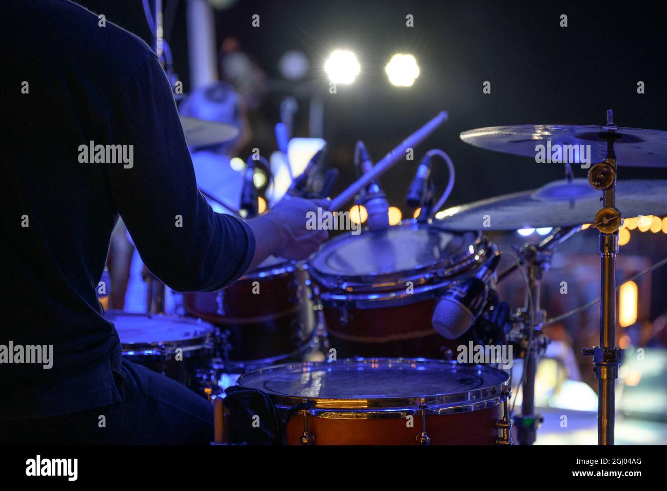 Drummer is playing the drums on stage at the event Stock Photo - Alamy