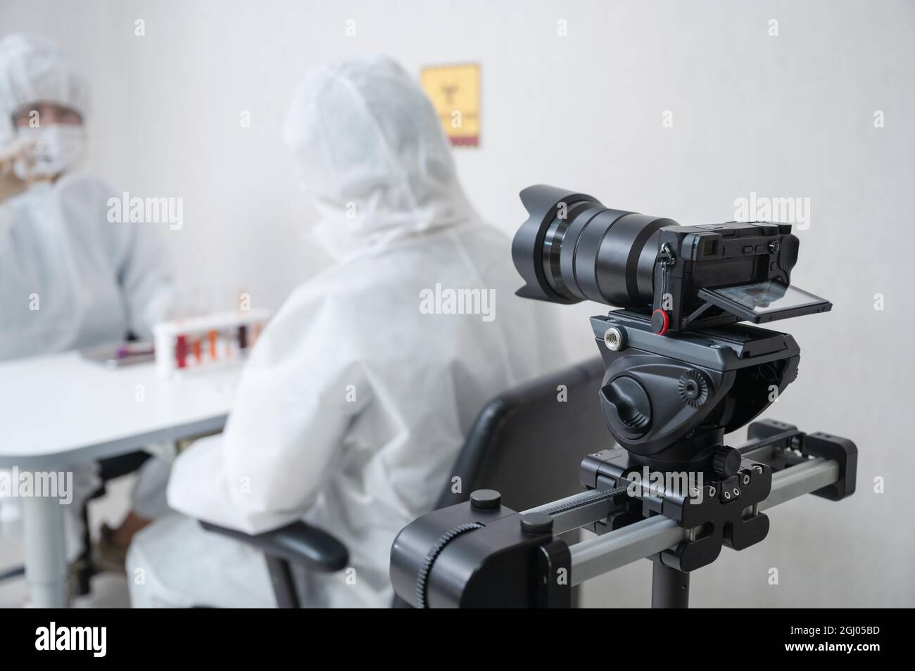 Mirrorless camera on slide rail filming scientists experimenting ...
