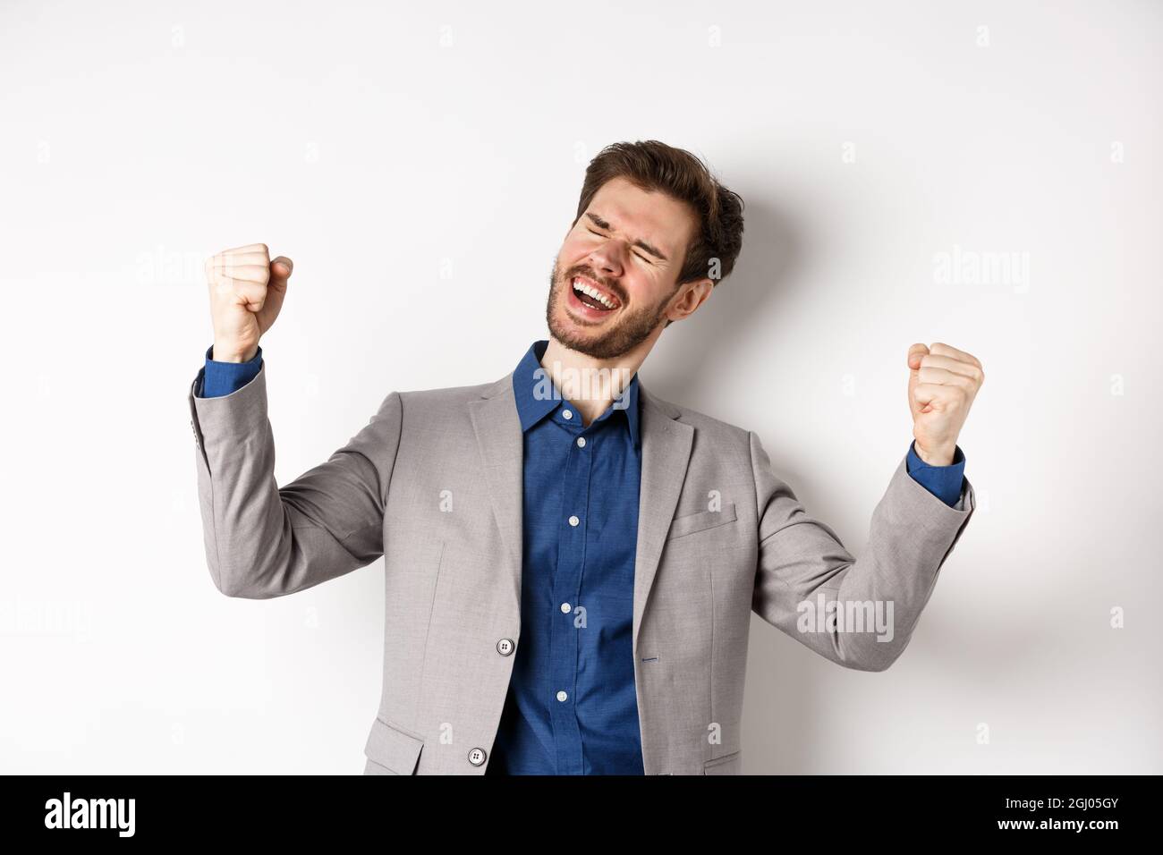 Successful business man in suit winning prize, shouting yes with ...