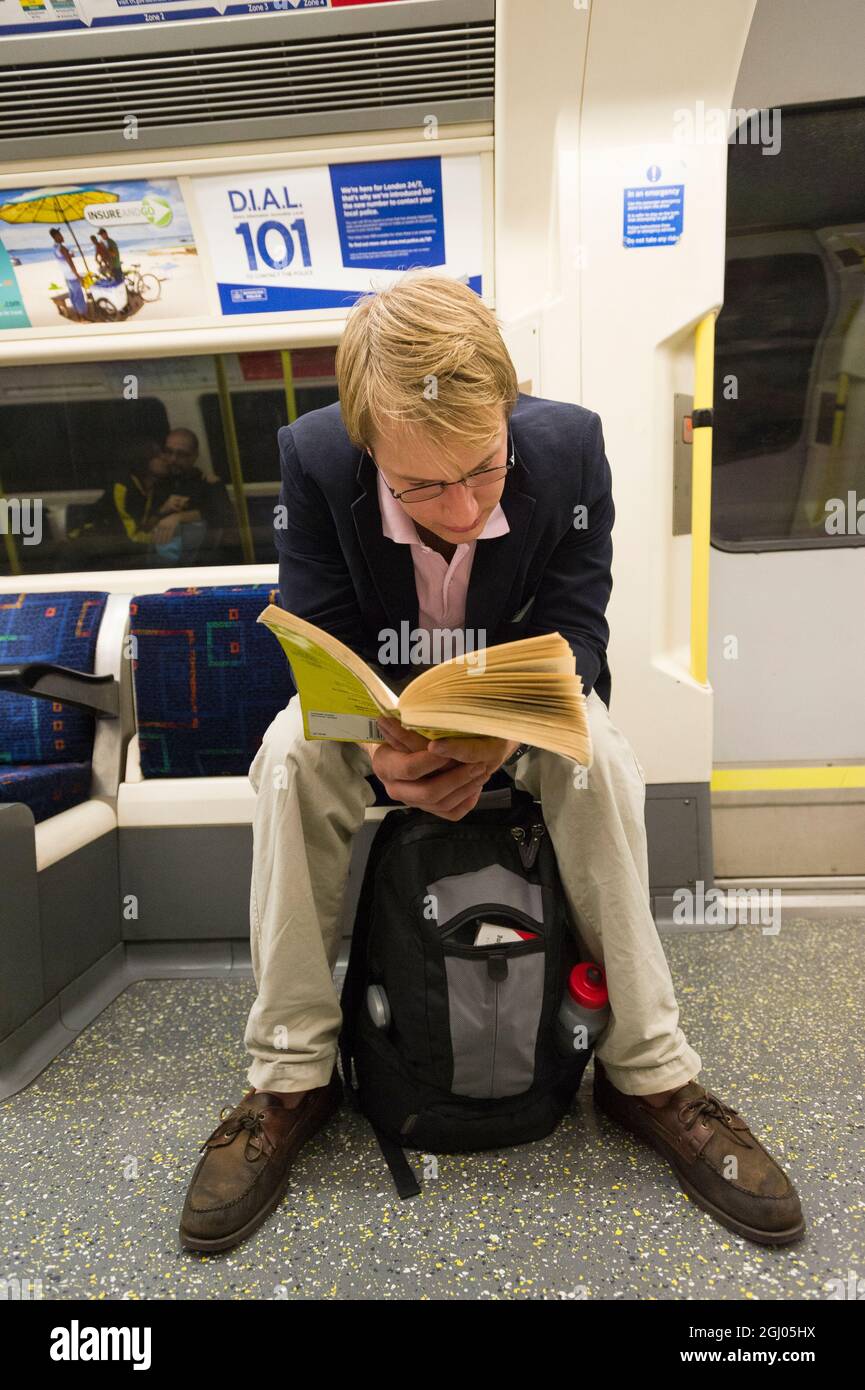 Passengers reading a book, on a north bound Northern Line tube train ...