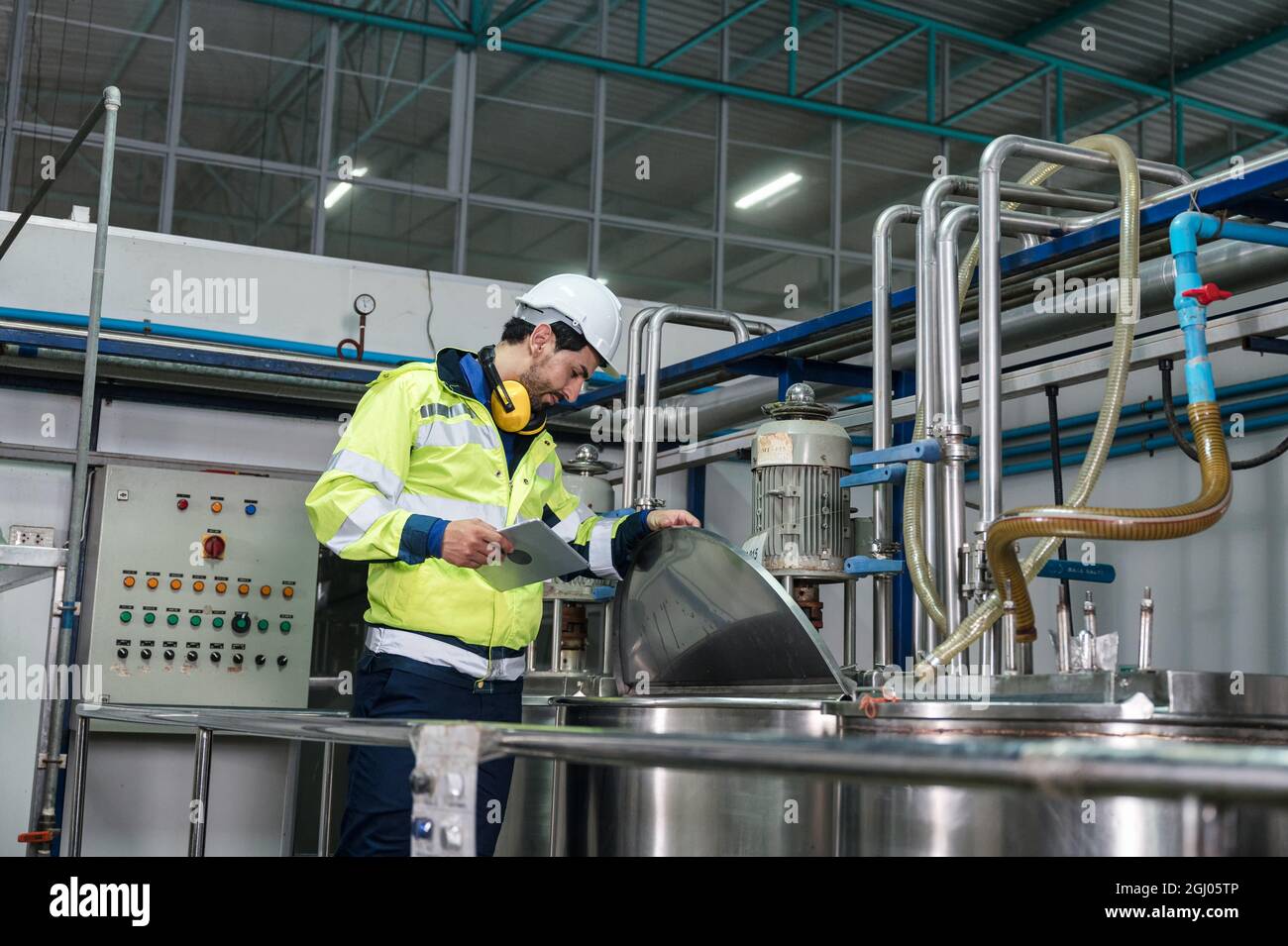 Caucasian engineer man in uniform walking to check boiler tanks with ...