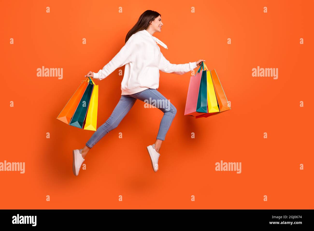 Full length body size view of beautiful cheerful girl jumping carrying ...