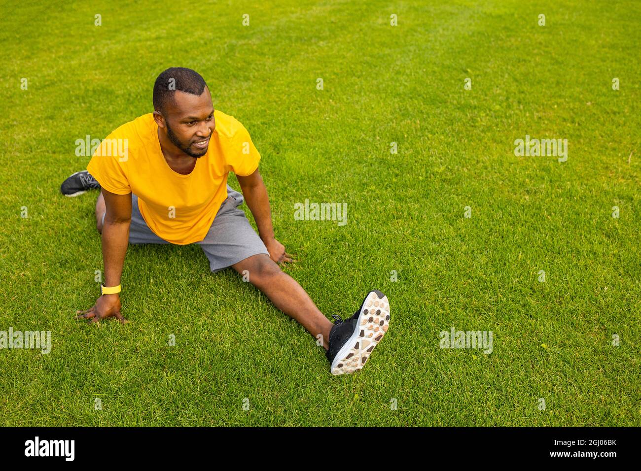 Smiling african american male in stylish sportswear sitting at the ...