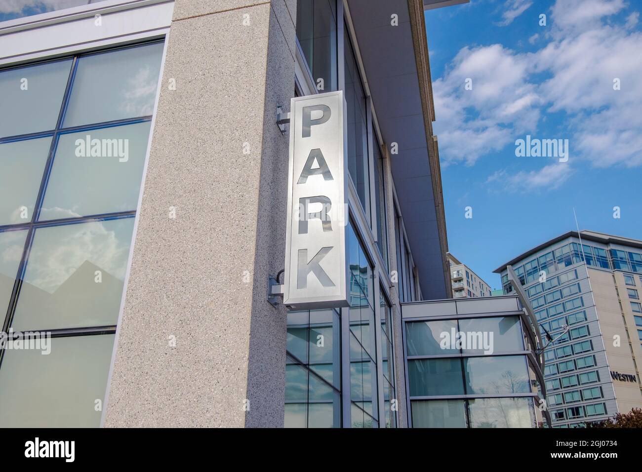 A shiny, silver, new Park sign for a garage at a modern office building ...