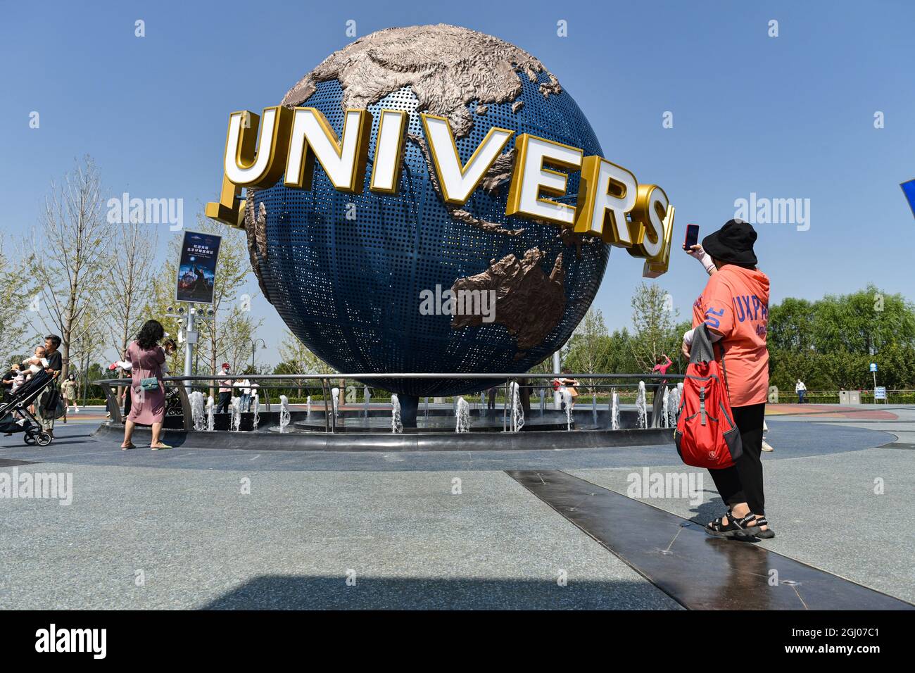 Tourists take pictures in front of the landmark of the universal theme ...