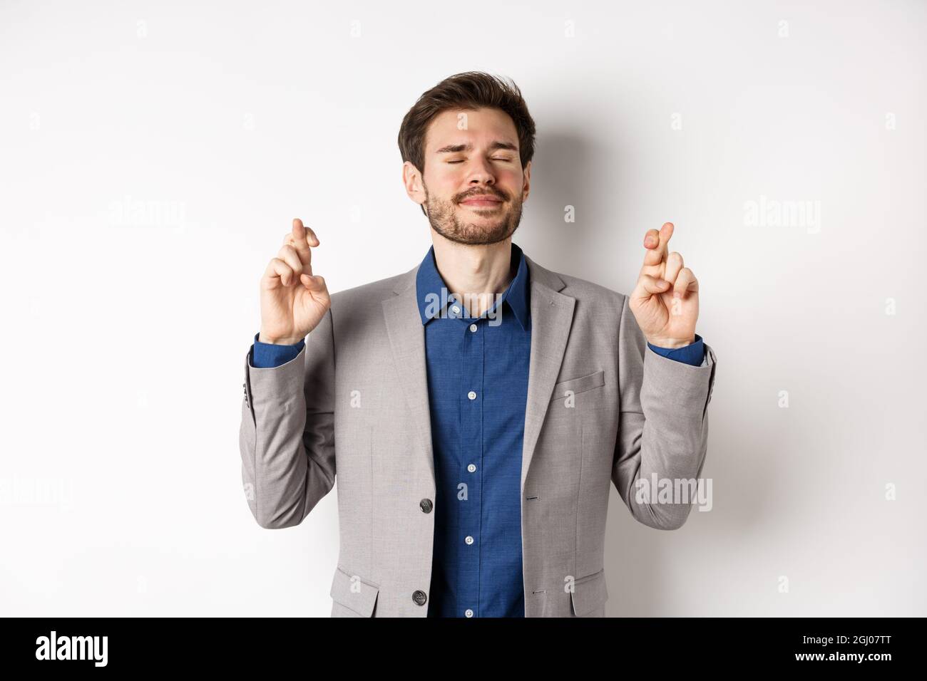 Nervous businessman in suit begging god, holding fingers crossed with ...