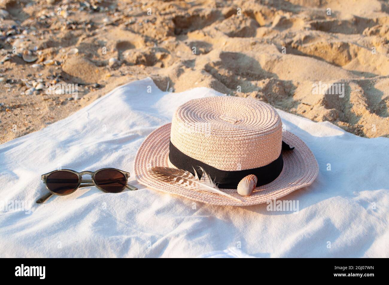 Summer set with a hat and sunglasses on the beach by the sea at a ...