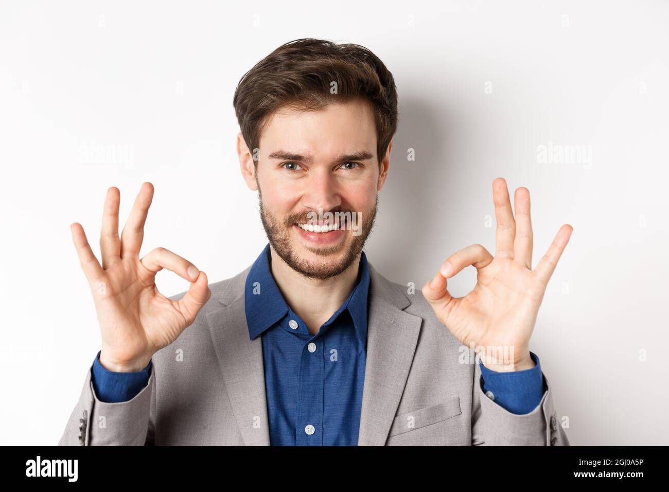 Smiling businessman in suit showing okay signs in approval, guarantee ...