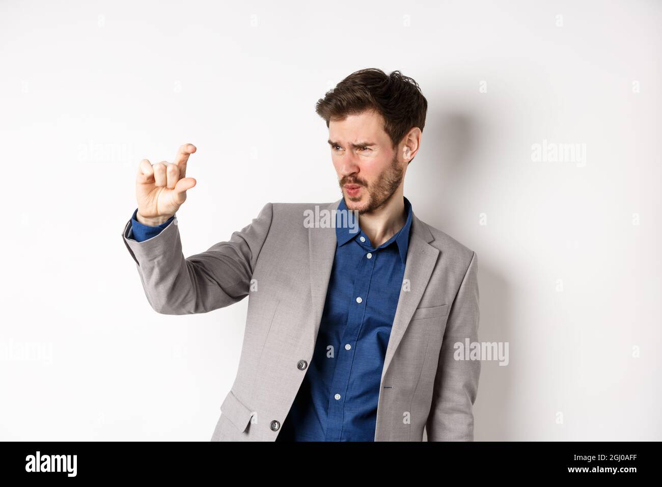 Businessman trying to see something small, showing little thing size ...